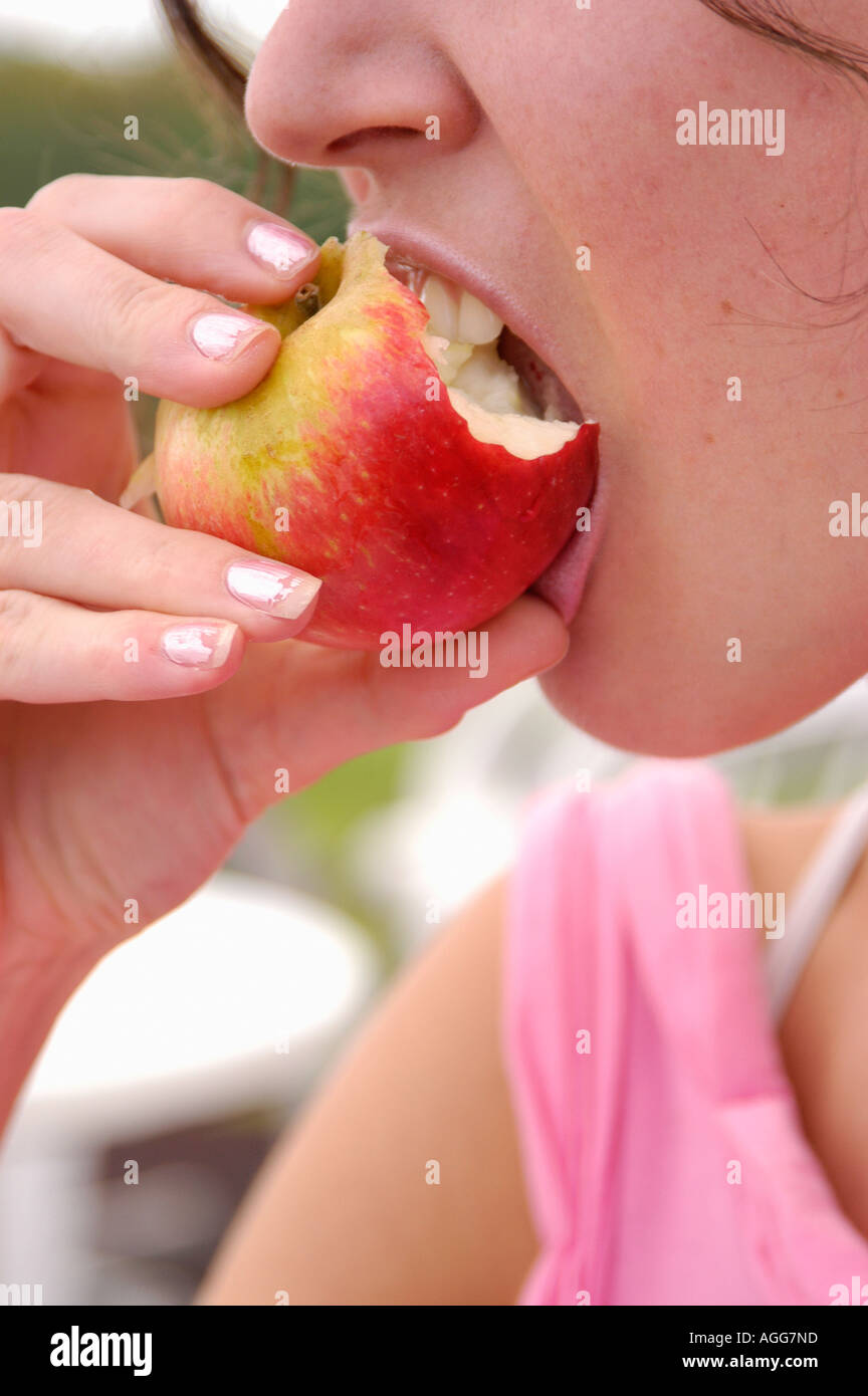 young woman taking a bite off an apple Stock Photo - Alamy
