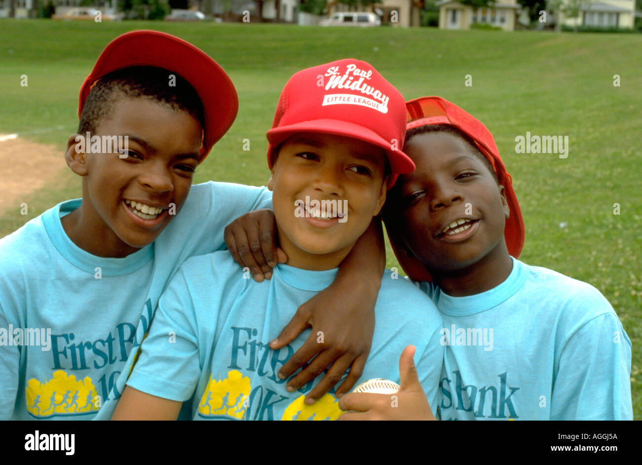 Black happy inner city ball player friends age 10 with arms around each ...