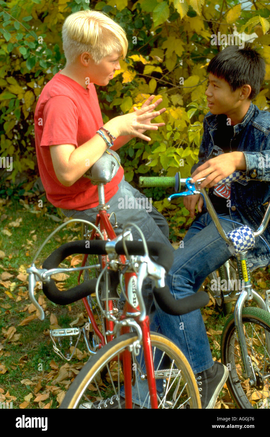 Cambodian American and friend age 14 sitting on bikes talking. St Paul ...
