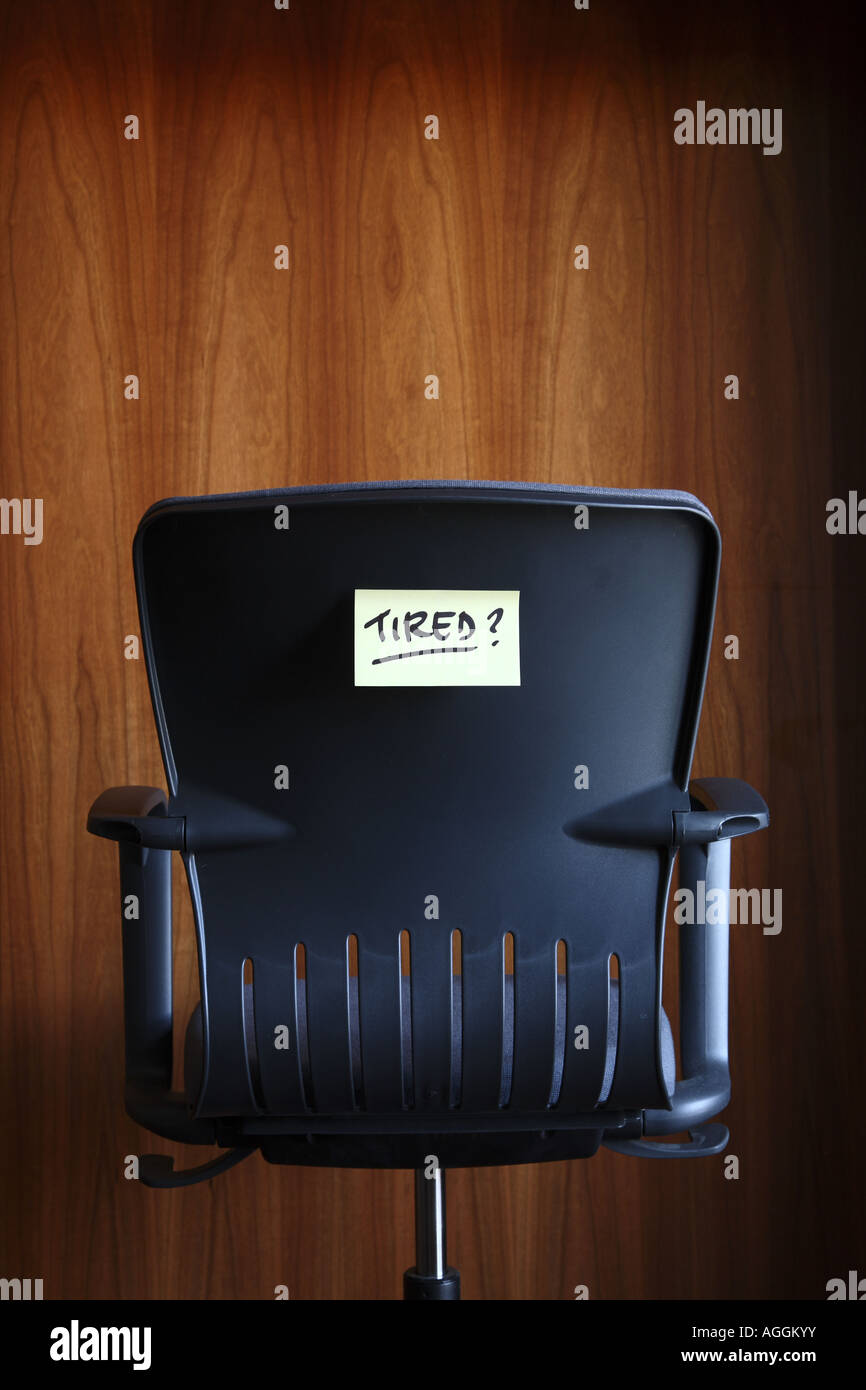tired ? written on a post it note sticked on a armchair in an office ...