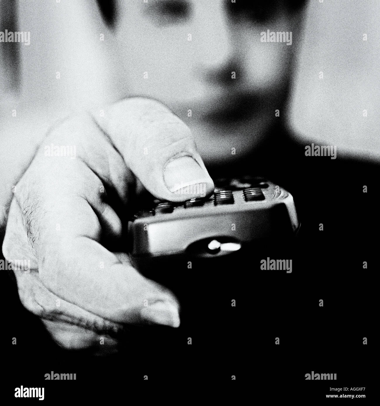 black and white toned image of man pointing television remote control ...