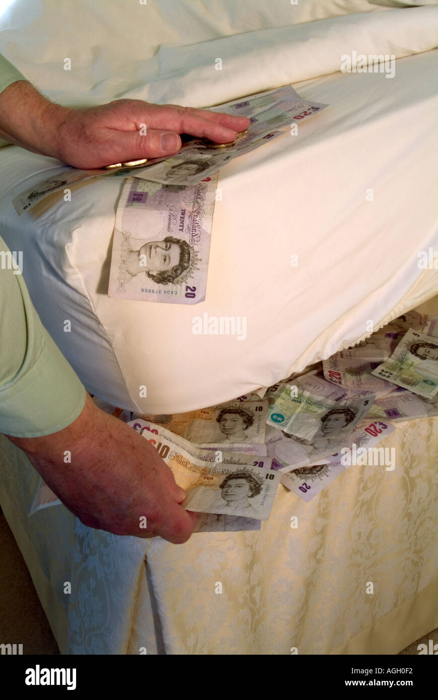 Bank notes hidden under bed mattress with hand sorting pound sterling ...