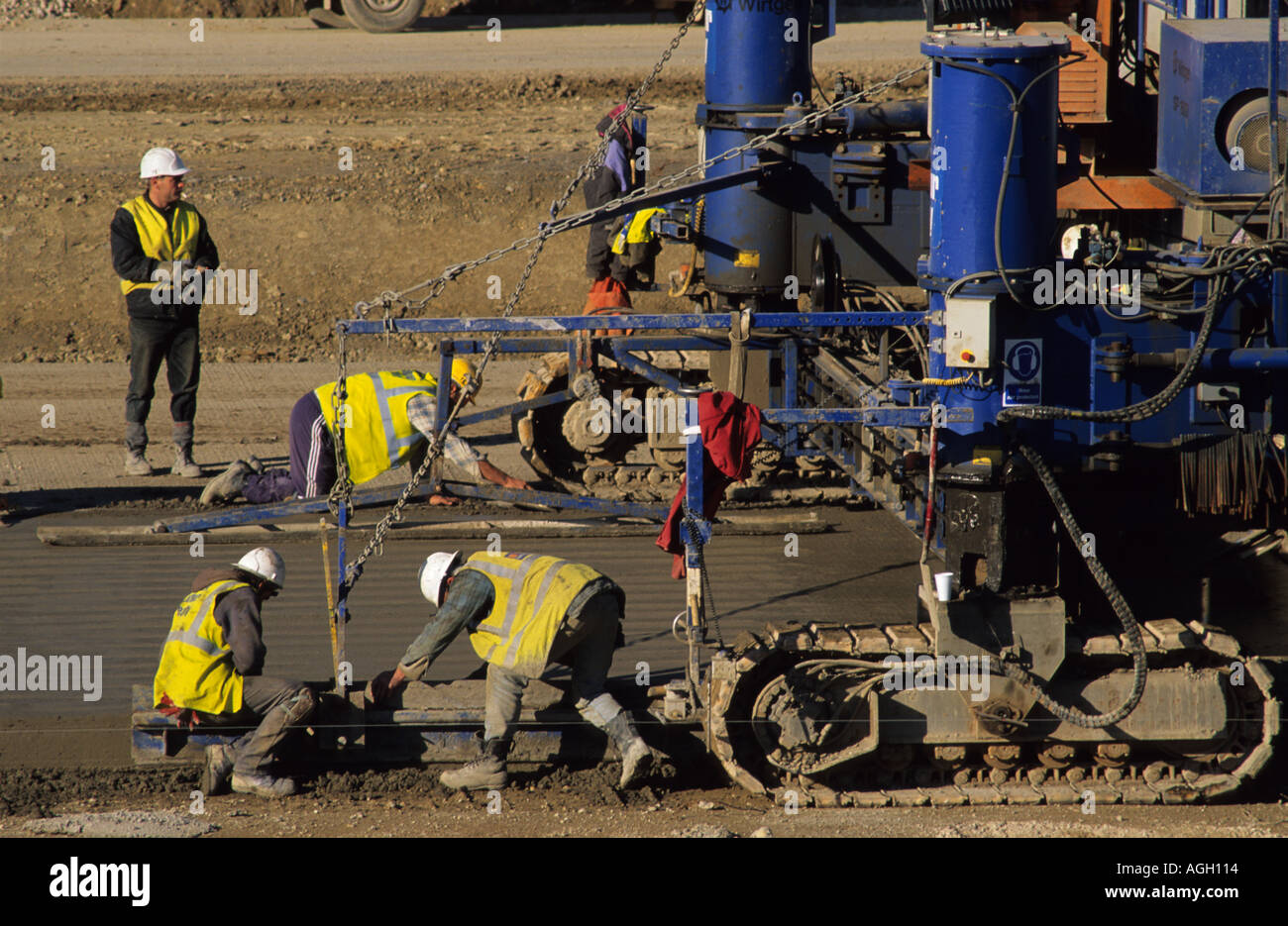 construction workers and surfacing machine laying road surface for the ...