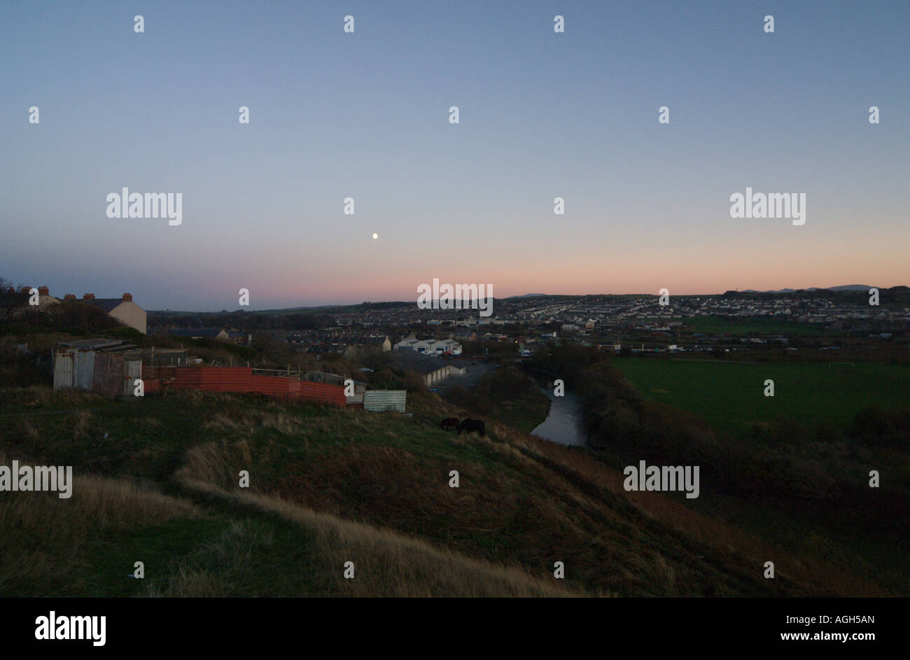 Dusk looking over Cumbrian town of Maryport with moon ponies and houses ...