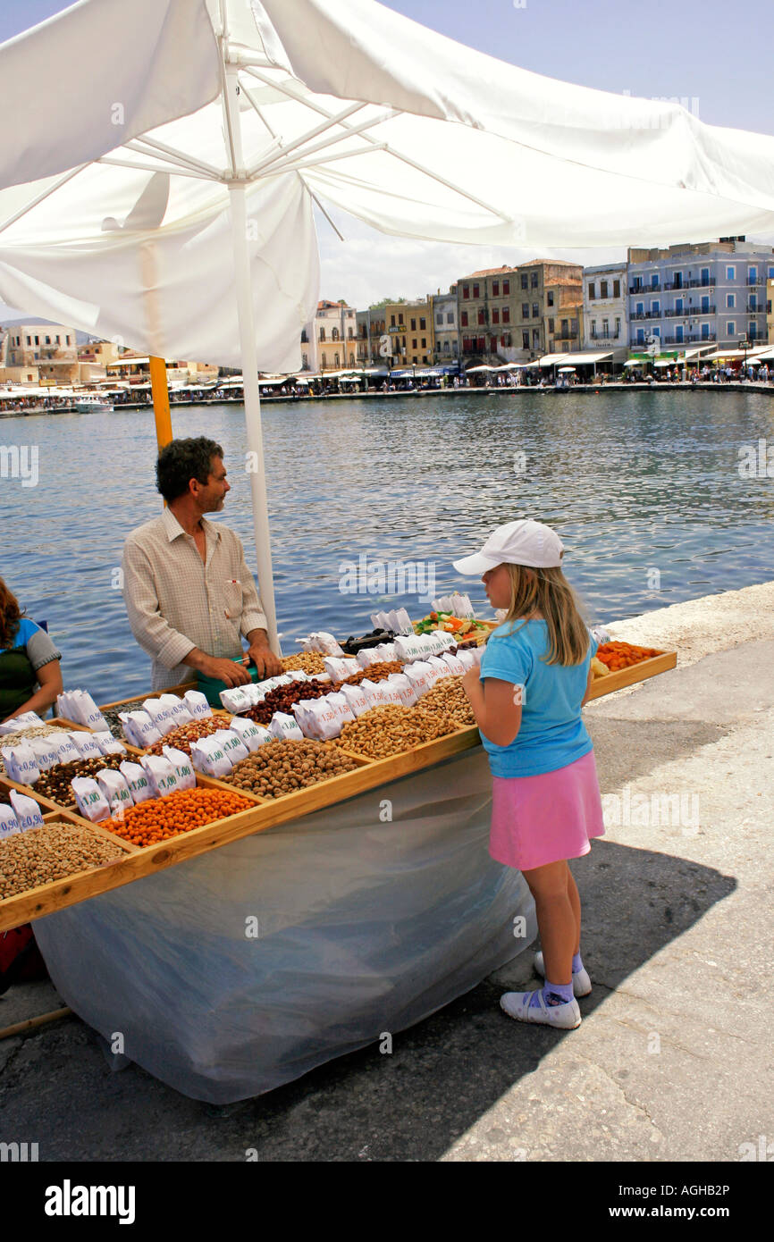 A CHILD PURCHASING NUTS FROM A STREET VENDOR. THE HARBOUR HANIA. CRETE ...
