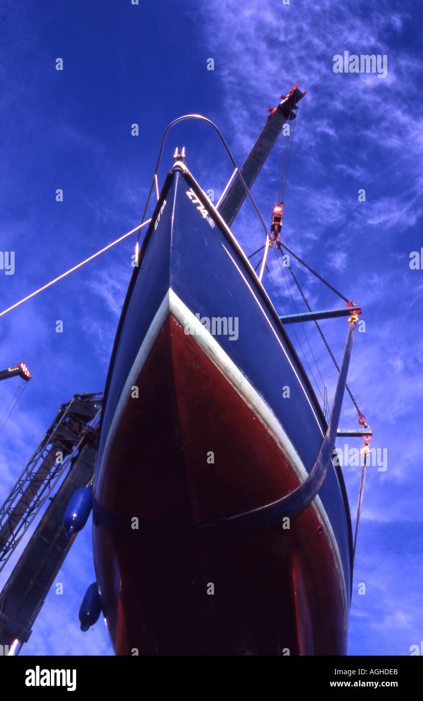 Crane lifting sailing boat out of water Stock Photo - Alamy