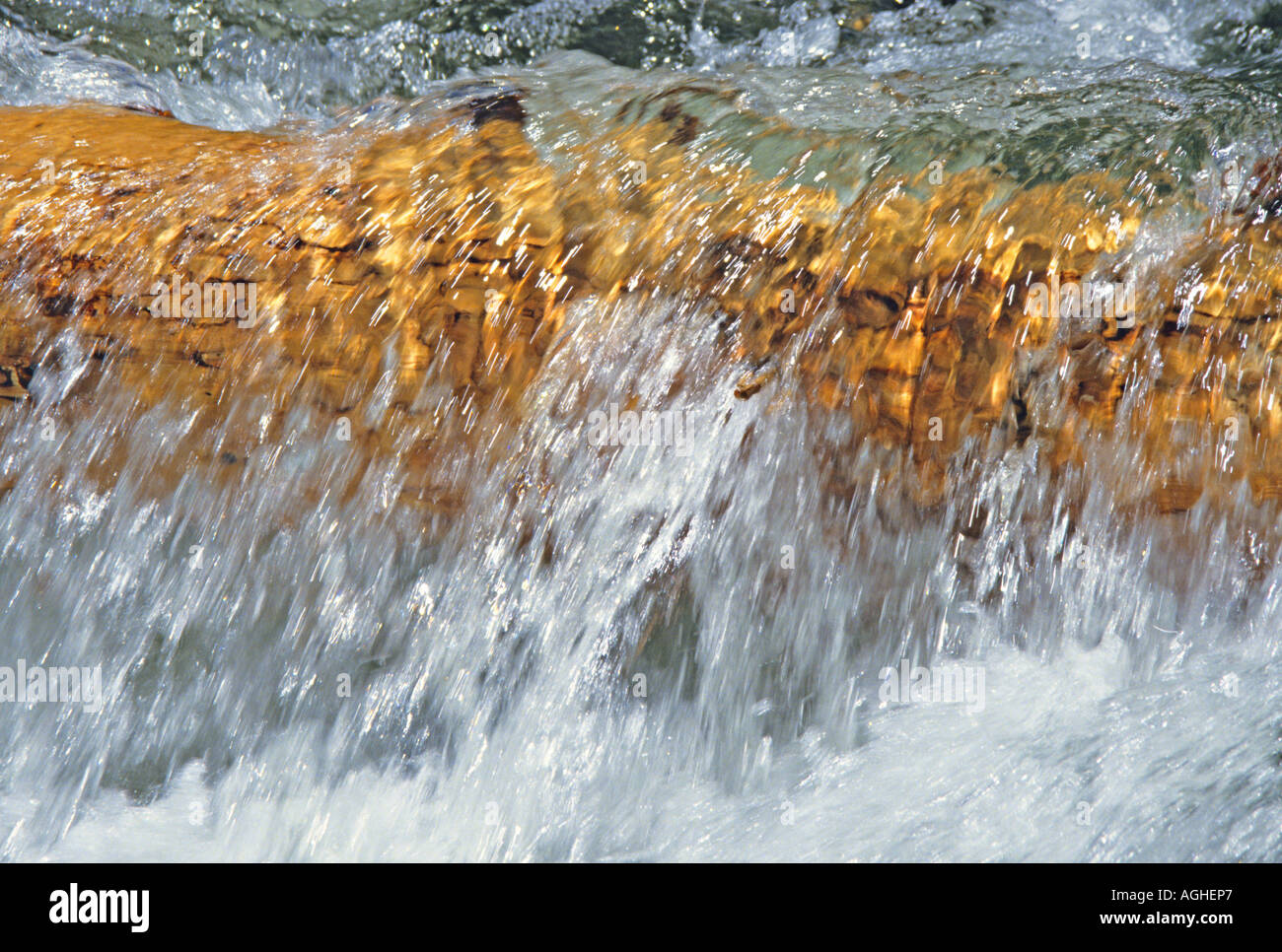 Creek water flowing over log Stock Photo - Alamy