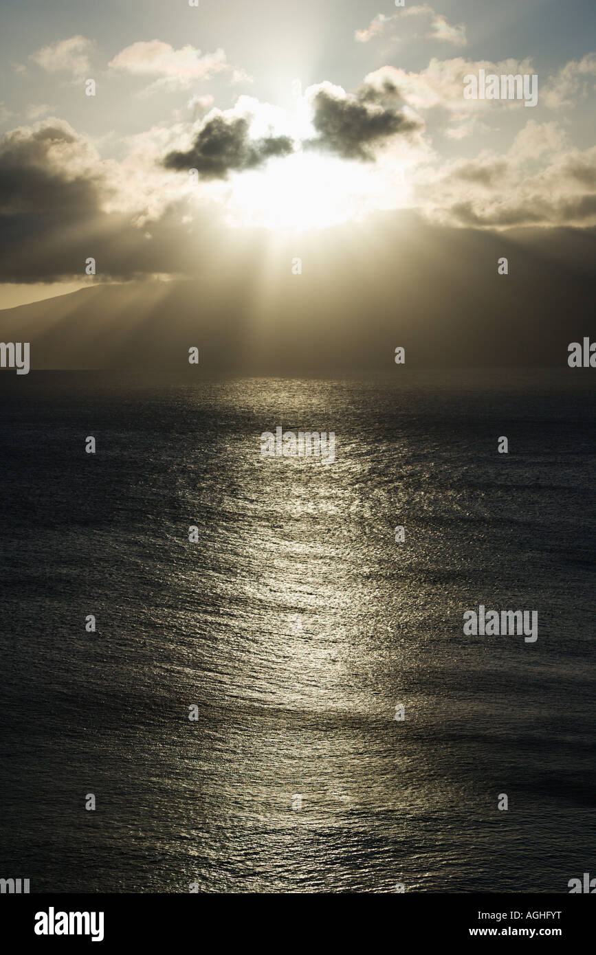 Pacific ocean and island with sun streaming through clouds Stock Photo ...