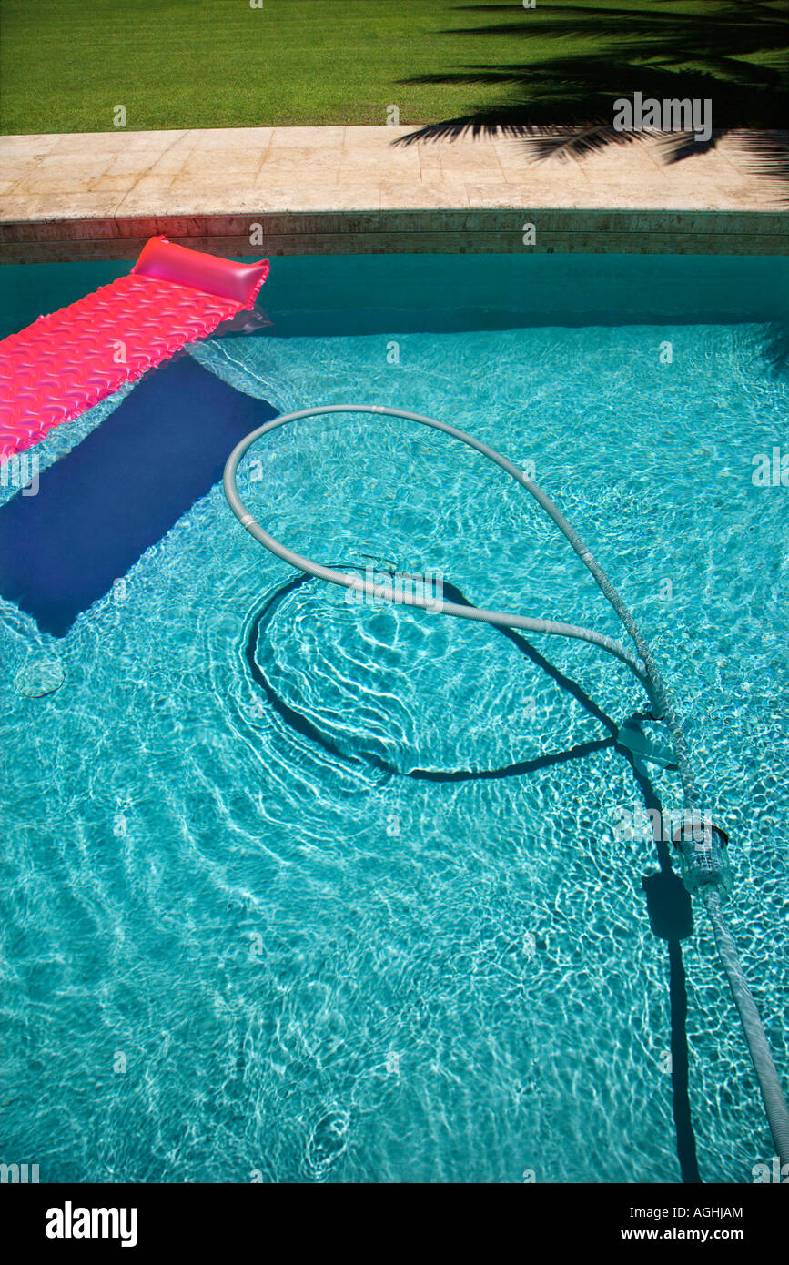 Pink float and vacuum hose in swimming pool Stock Photo - Alamy