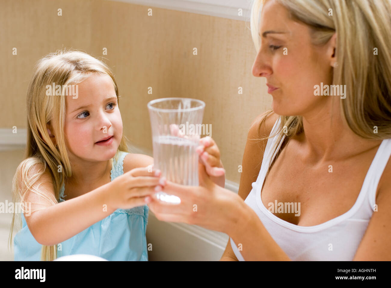 A mother giving her daughter a glass of water hi-res stock photography ...