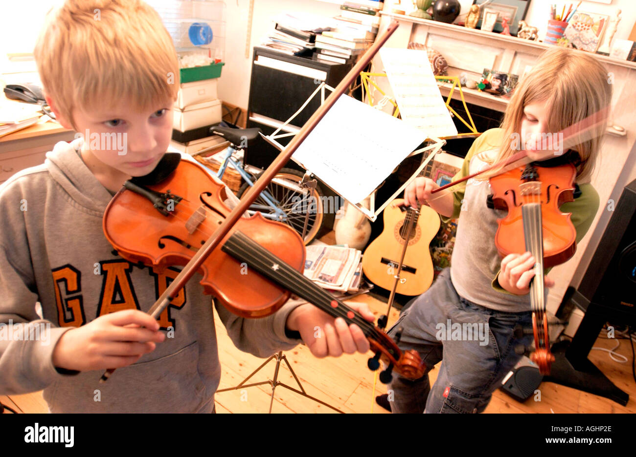 A brother and sister do their daily violin practice in a crowded ... A brother and sister do their daily violin practice in a crowded ...