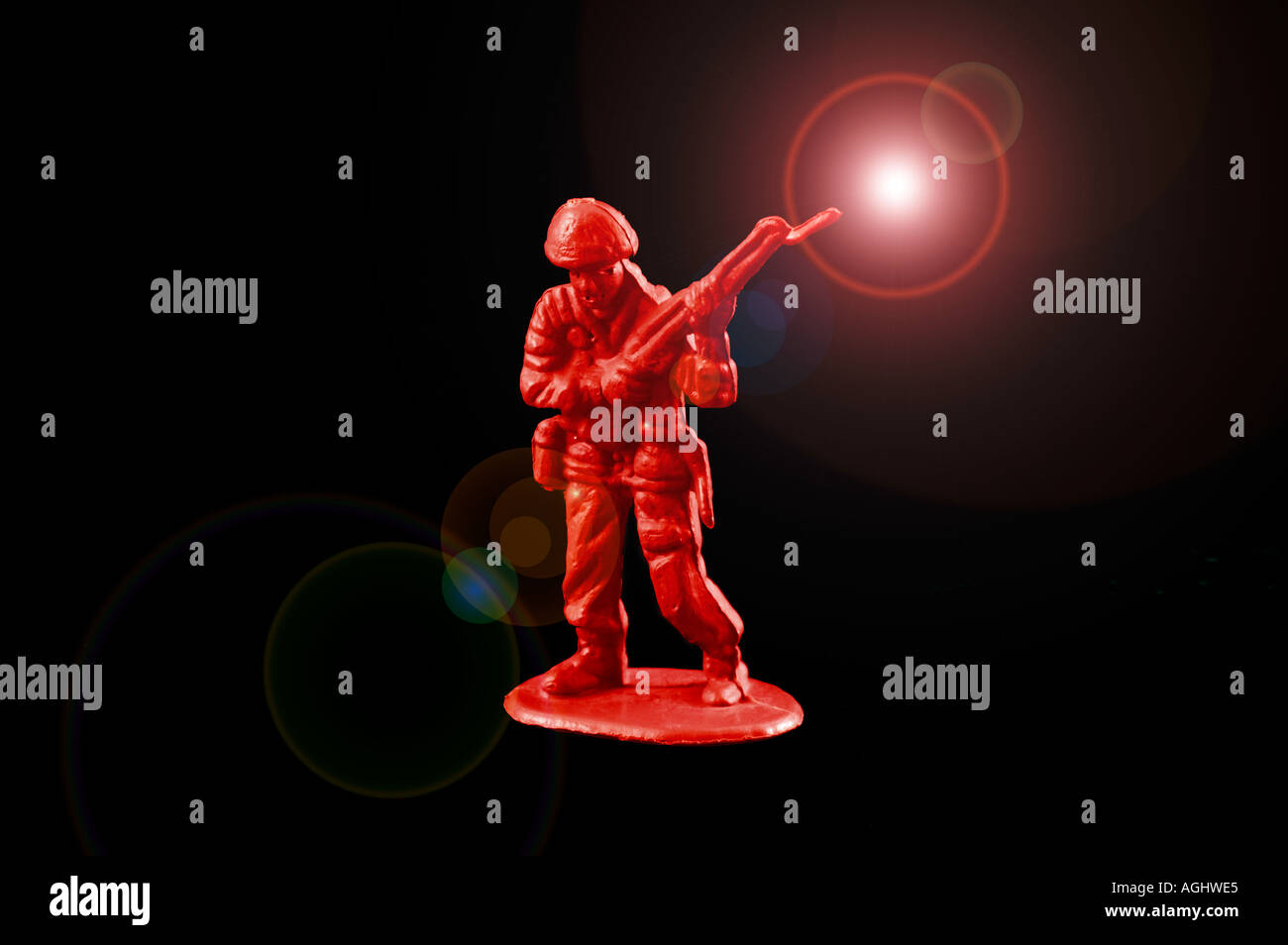 One blood red plastic toy soldier with lens flare against a black ...