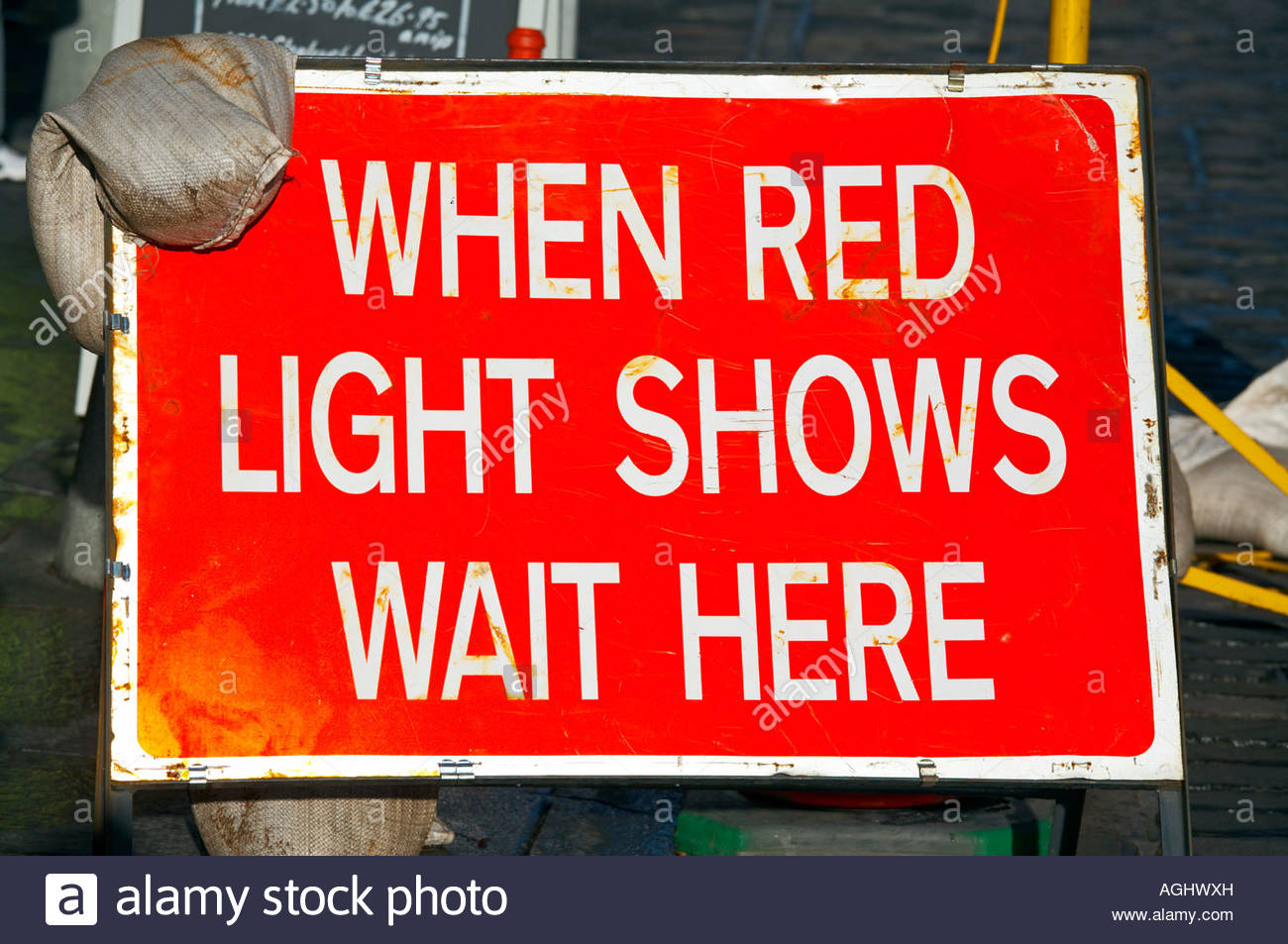 When red light shows wait here signpost Stock Photo - Alamy