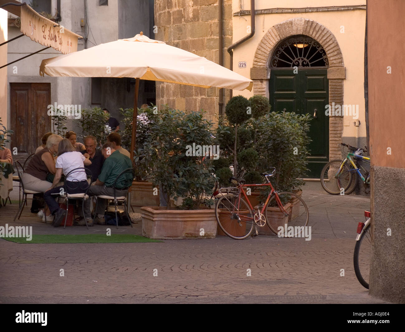 People dining at outdoor table at cafe in Lucca Italy Stock Photo - Alamy
