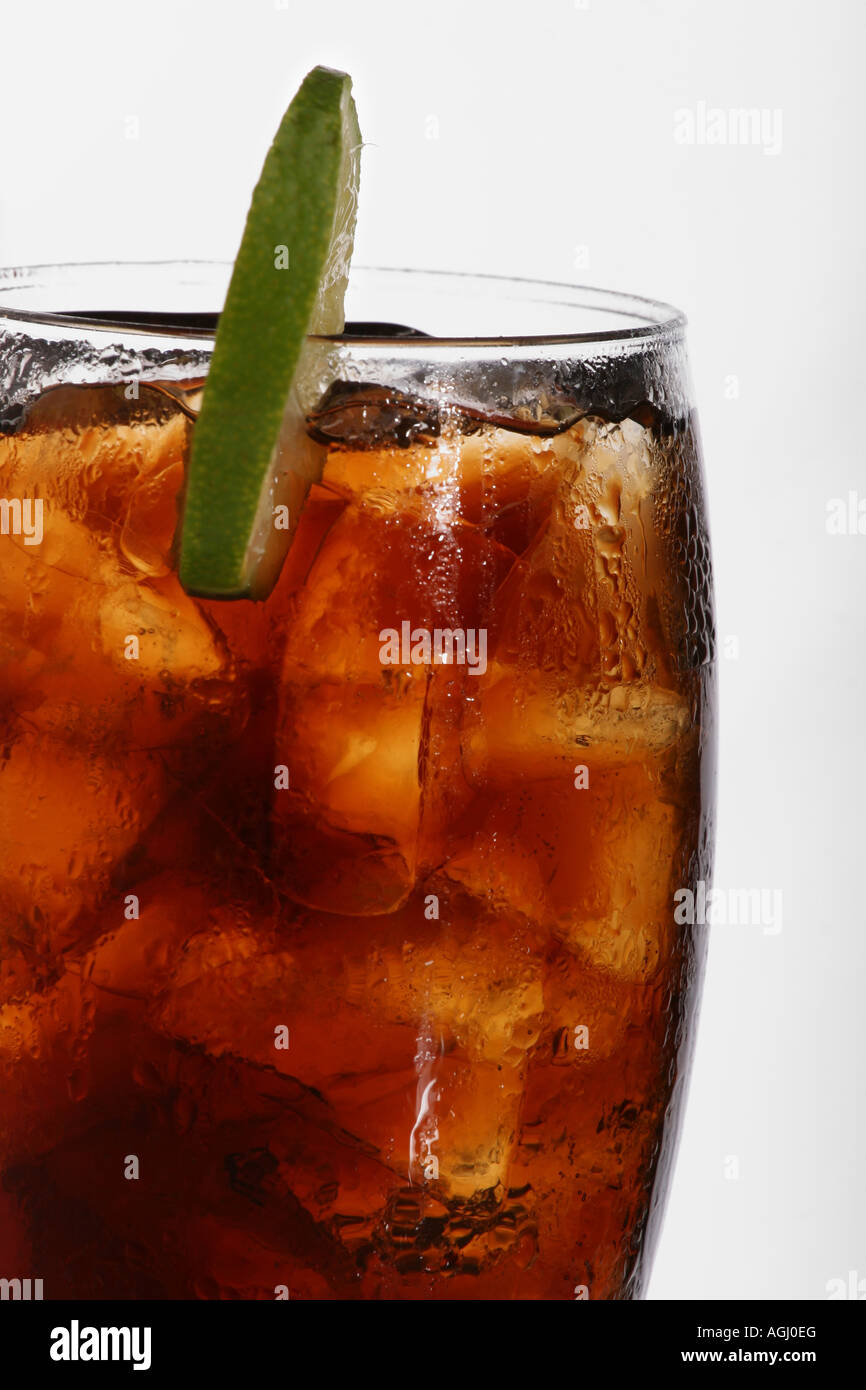 A glass of Coca Cola with ice cubes and a slice of green lime Coke soft ...