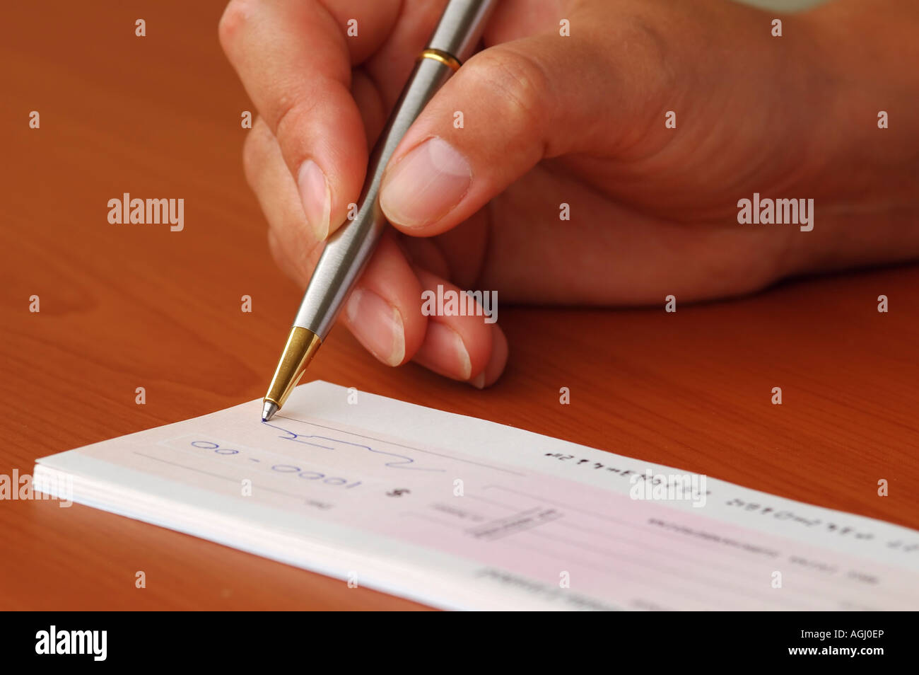 Signing a money cheque Stock Photo - Alamy