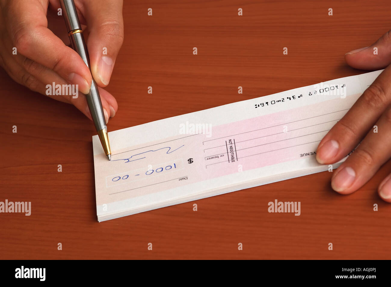 Signing a money cheque Stock Photo - Alamy