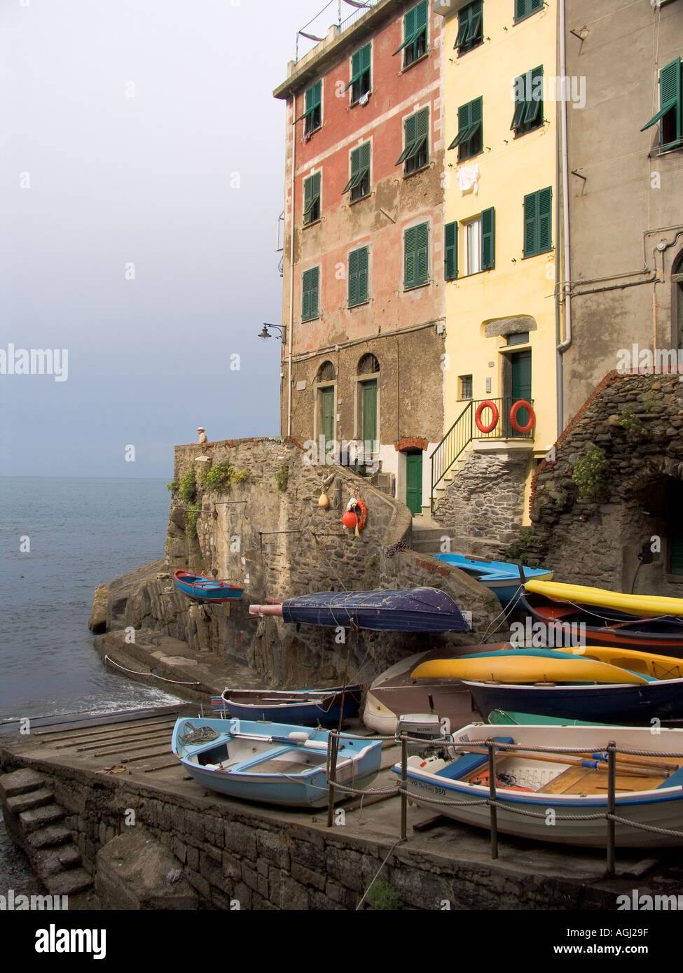 Fishing boats resting on stone boat ramp below colorful houses in the ...