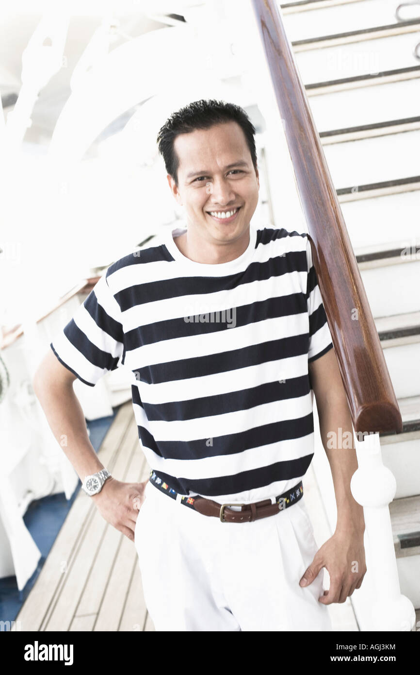 Portrait of a young man leaning against a banister and smiling Stock ...