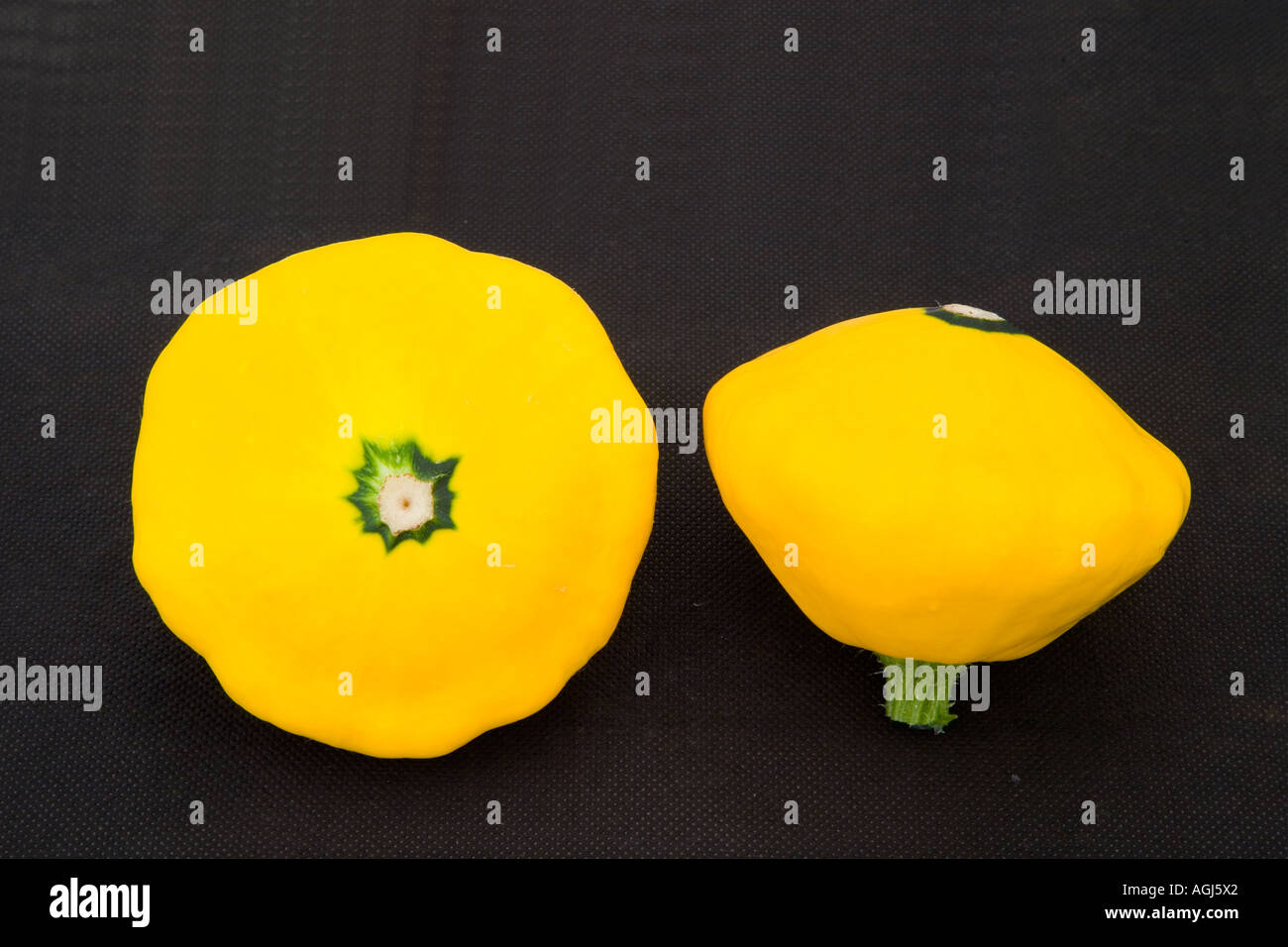 2 yellow harlequin squashes on black background Stock Photo - Alamy