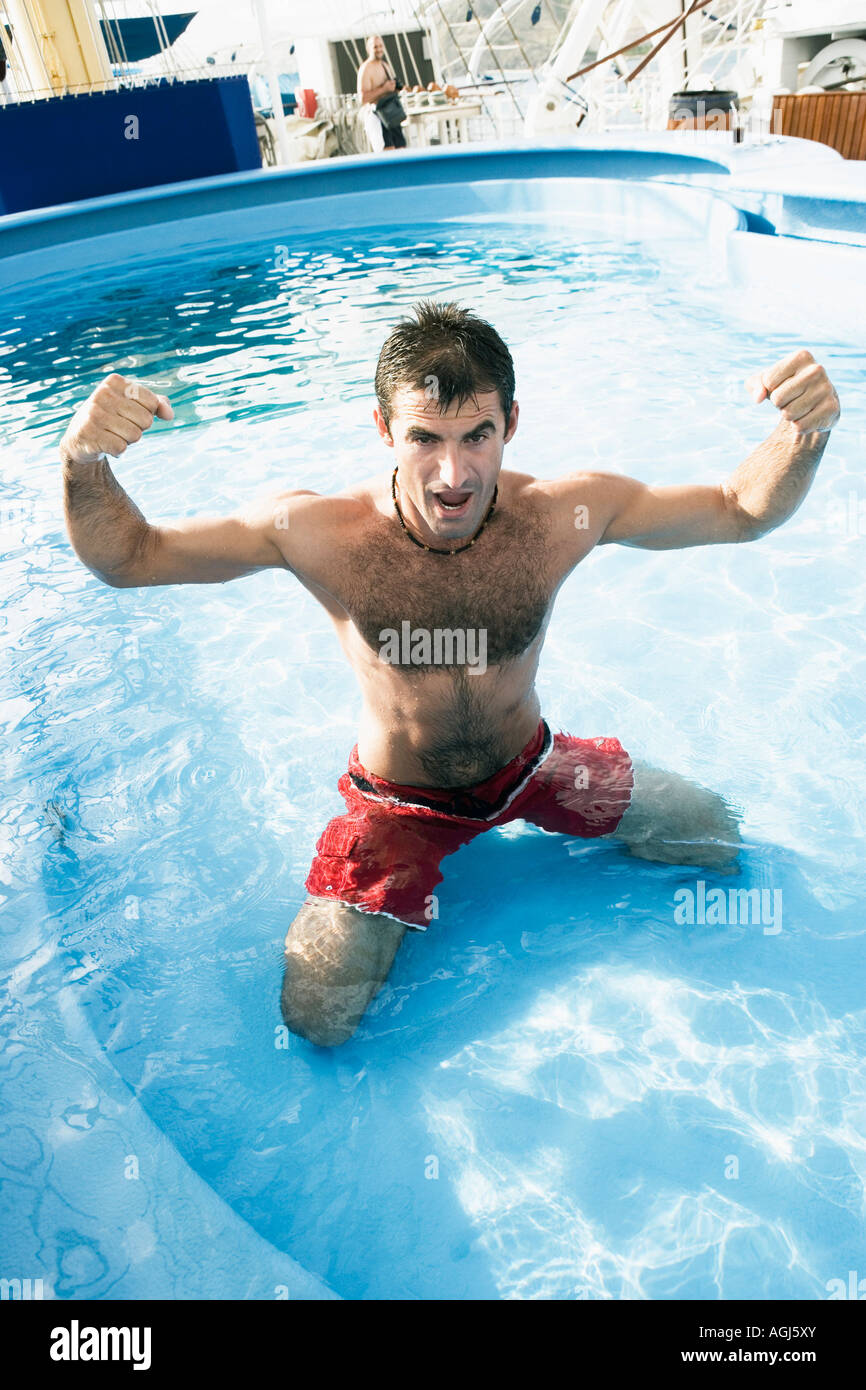 High angle view of a mid adult man flexing his muscles in a swimming ...