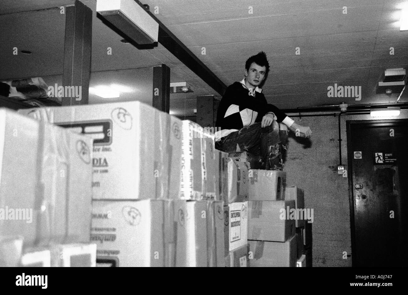 Portarait of young man sitting on boxes Stock Photo - Alamy