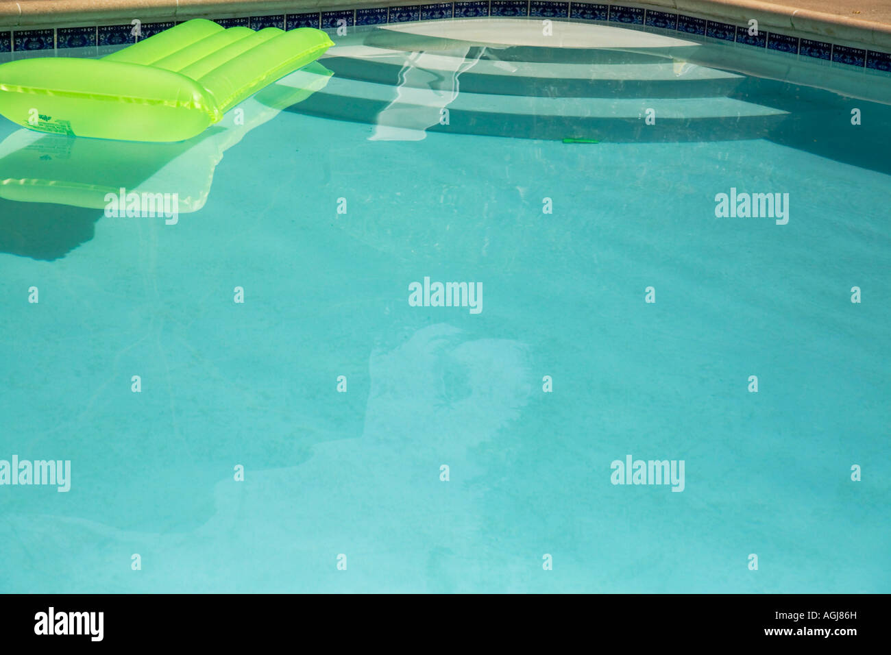 Green raft floating in a swimming pool Stock Photo - Alamy