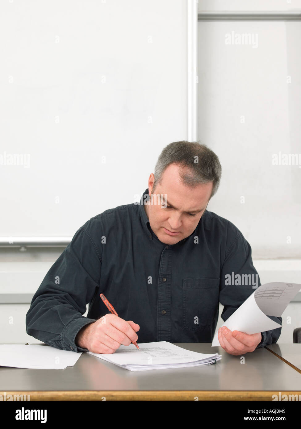 Teacher marking paper Stock Photo - Alamy