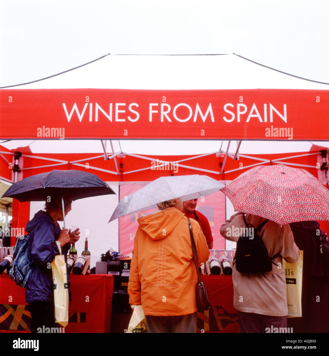 People in the rain at the "Wines from Spain" stall at the Guardian Hay ...