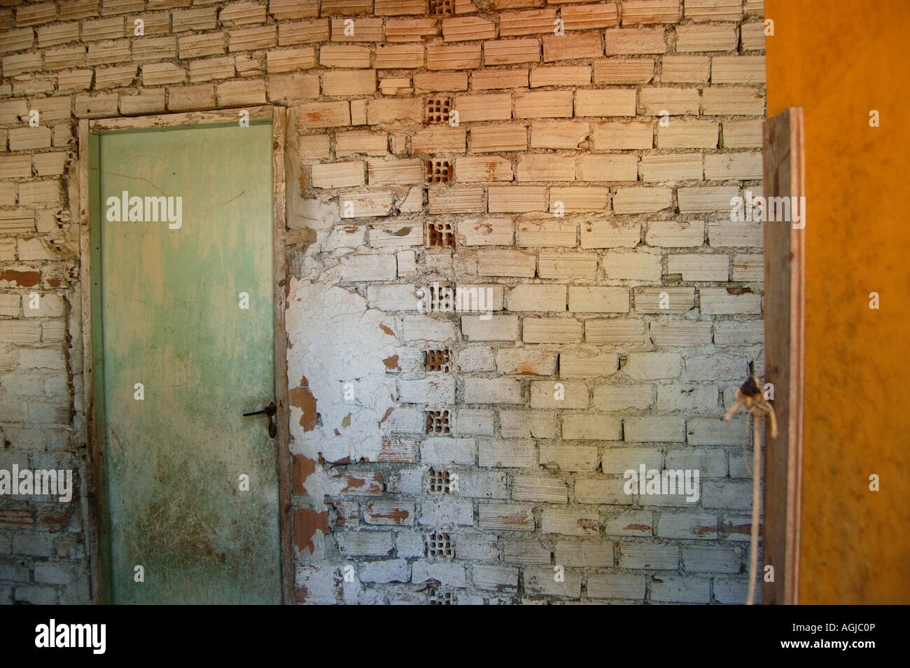 Empty room inside an abandoned house. White bricks and green door Stock ...