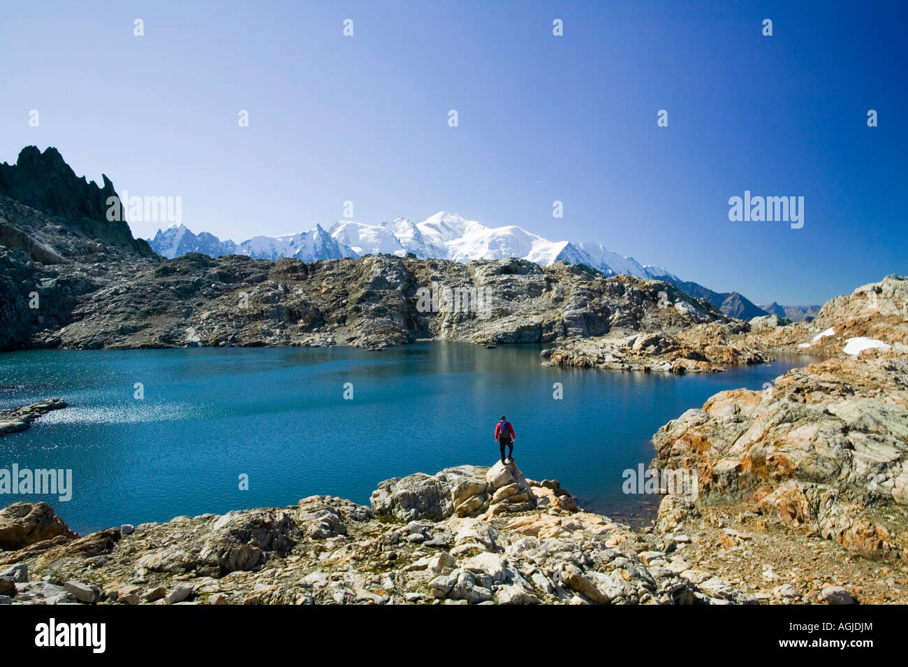 A walker looking towards Mont Blanc at Lac Noir on the Aiguille Rouge ...
