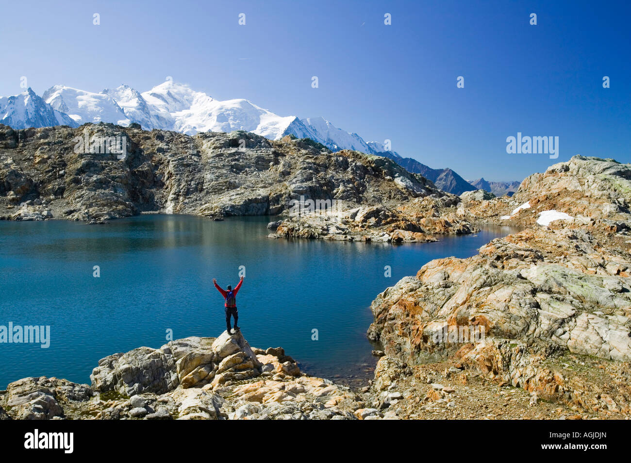 A walker looking towards Mont Blanc at Lac Noir on the Aiguille Rouge ...
