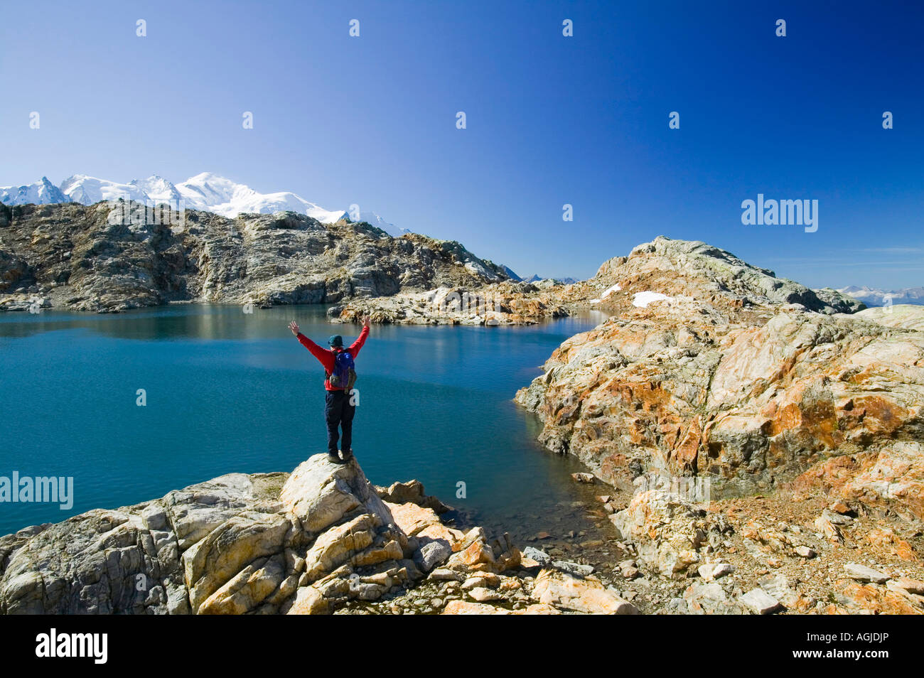 A walker looking towards Mont Blanc at Lac Noir on the Aiguille Rouge ...