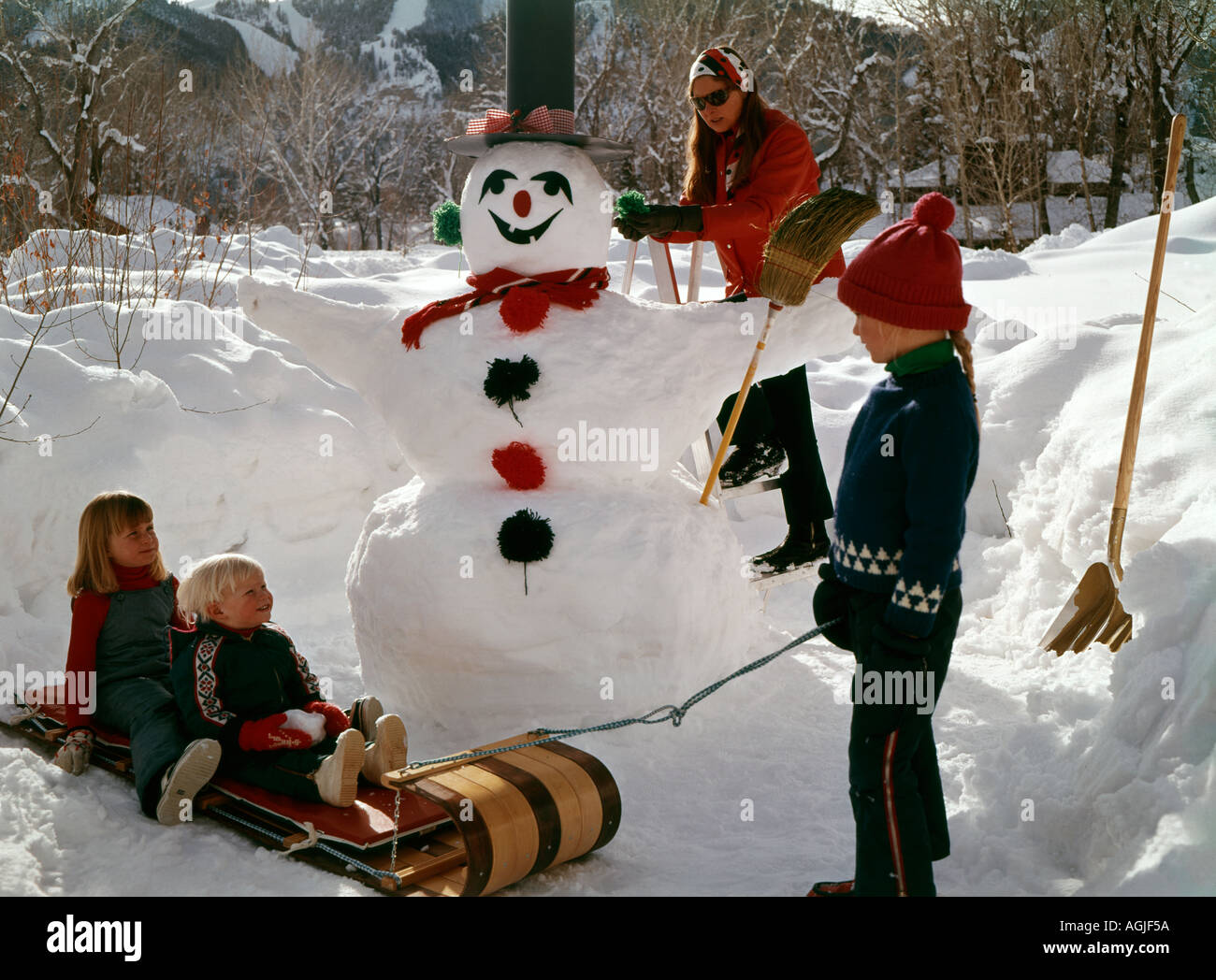Family building a snowman in a chilly winter scene Stock Photo - Alamy