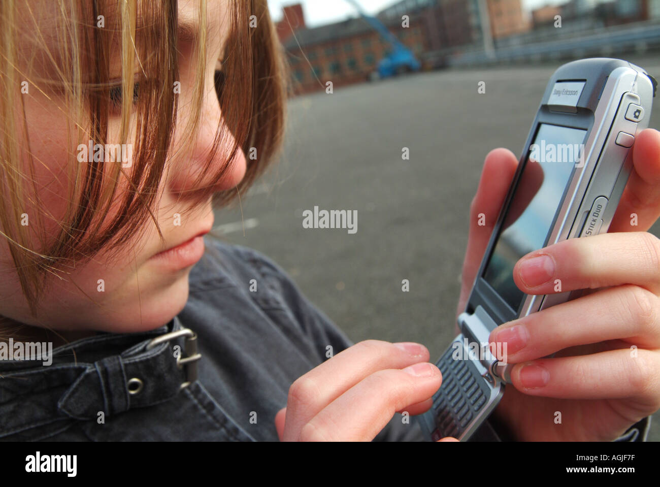 a girl typing a text message on a mobile phone Stock Photo - Alamy