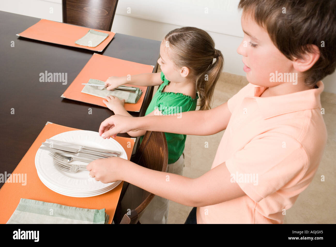Brother and sister setting the table Stock Photo - Alamy