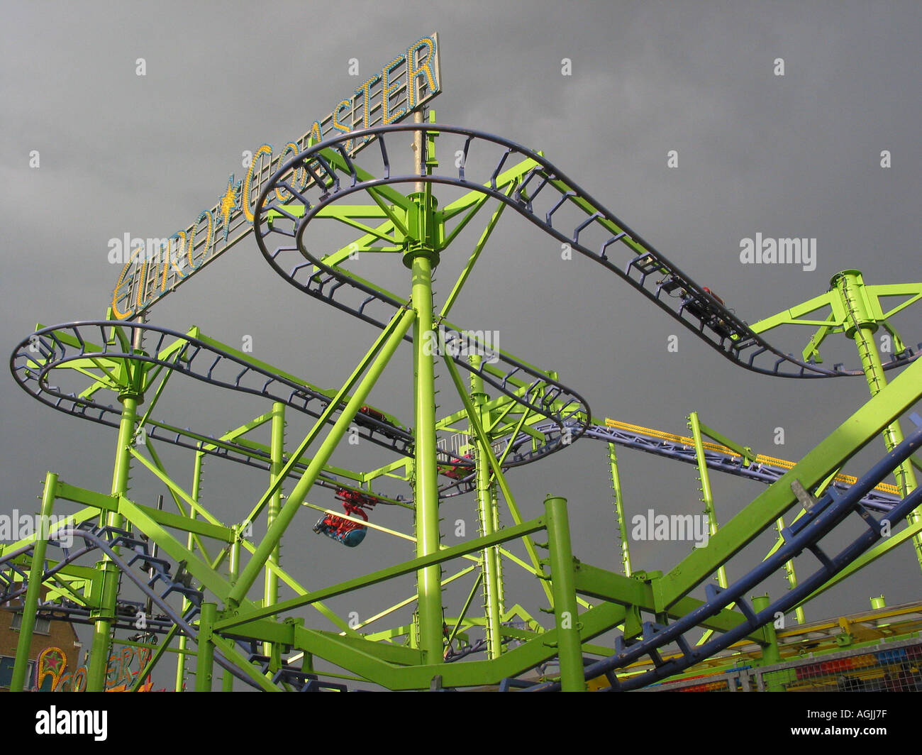 roller coaster at fairground against ominous sky with dark storm clouds ...