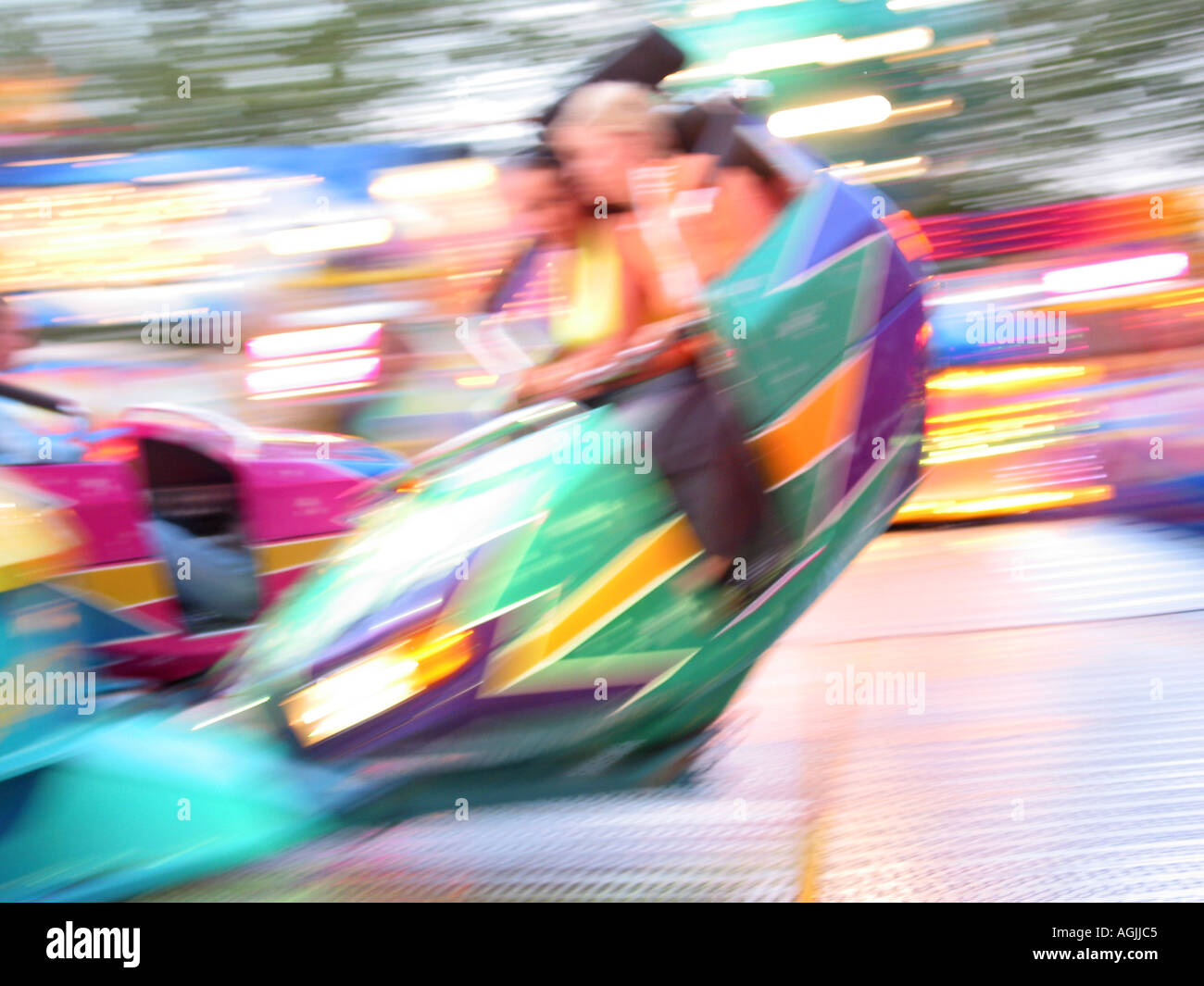 colourful fairground ride in motion with blurred people Stock Photo - Alamy