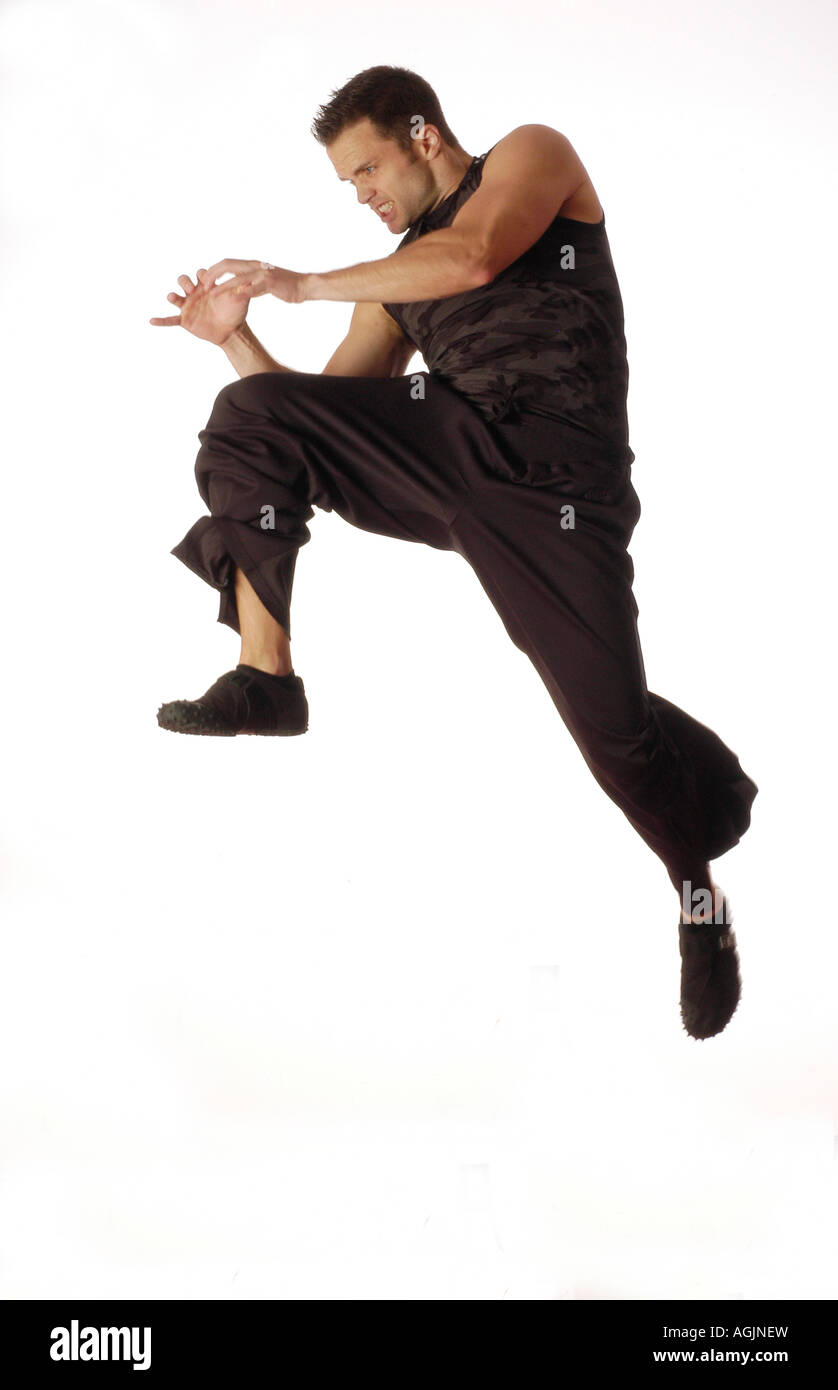 A young man does body attack kicks while teaching a body attack class ...