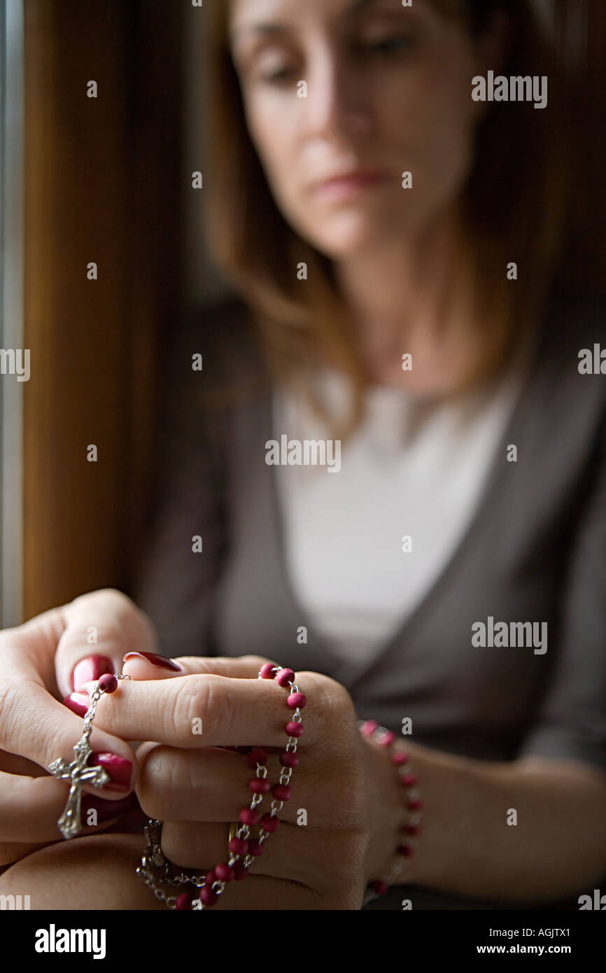 Woman praying rosary alone in hi-res stock photography and images - Alamy