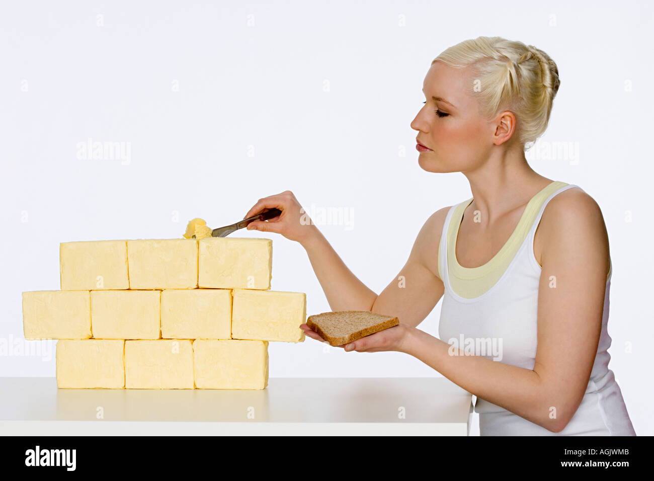 Young woman scraping butter Stock Photo - Alamy