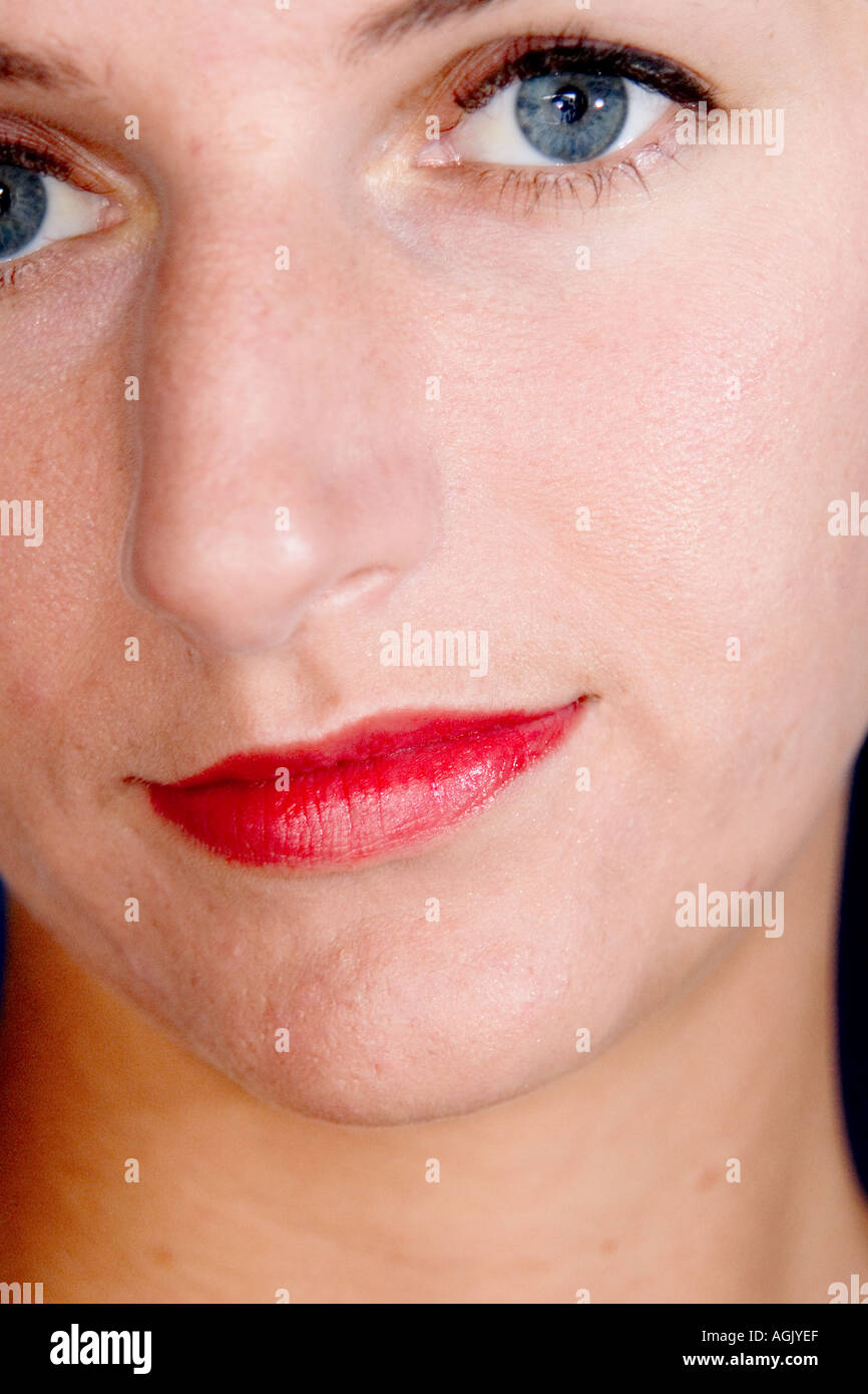 Portrait of a young woman with blue eyes and red lips almost smiling ...