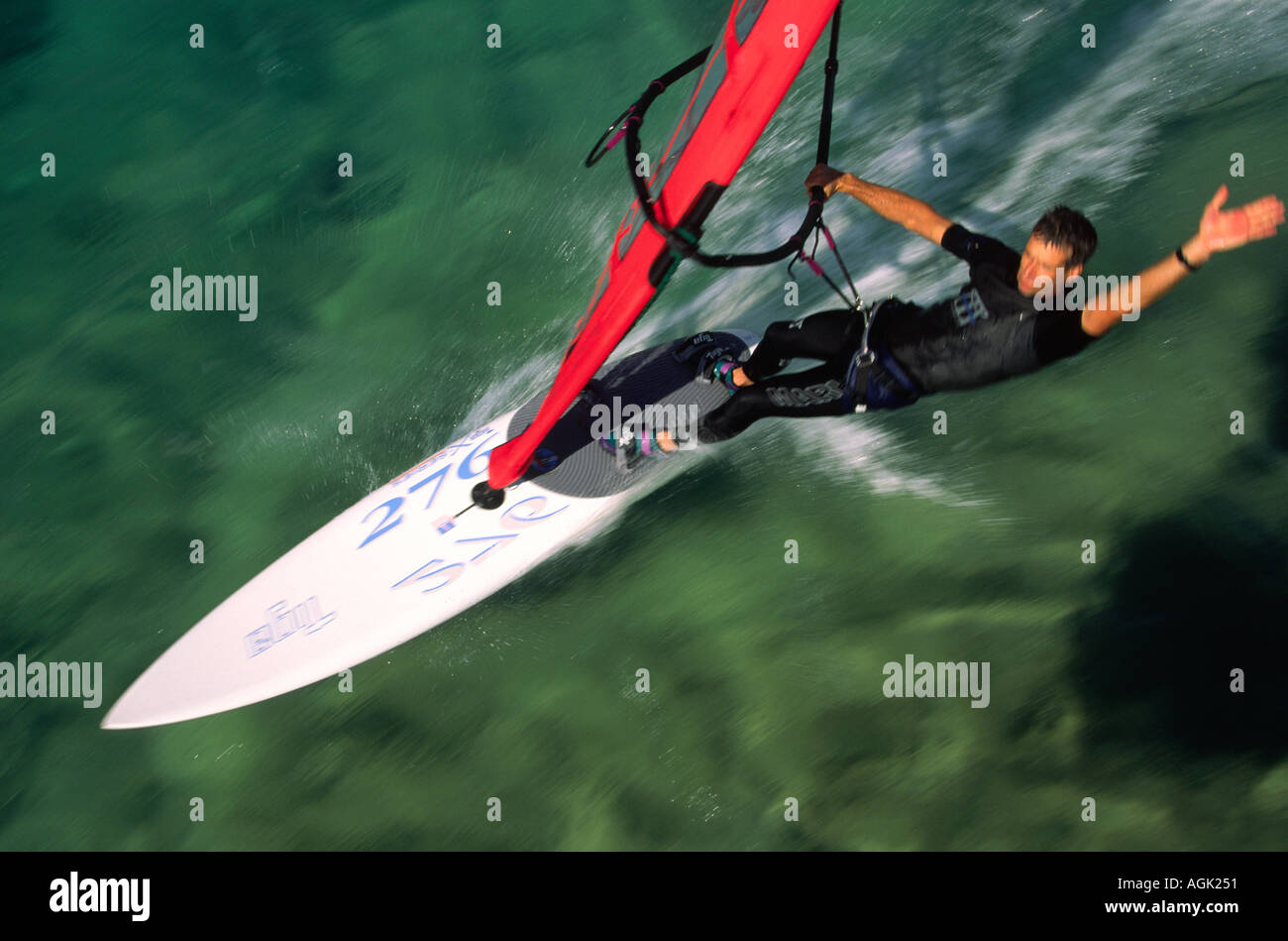 panning shot of windsurfer sailing one handed waving on Red Sea Dahab ...