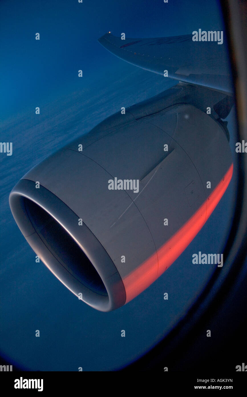 graphic shot of airplane wing and engine taken at sunrise showing pink ...