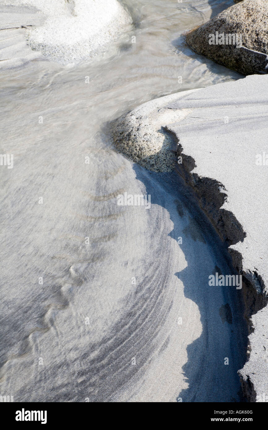 stream flowing through sand and rocks on Prth Nanven beach on the ...