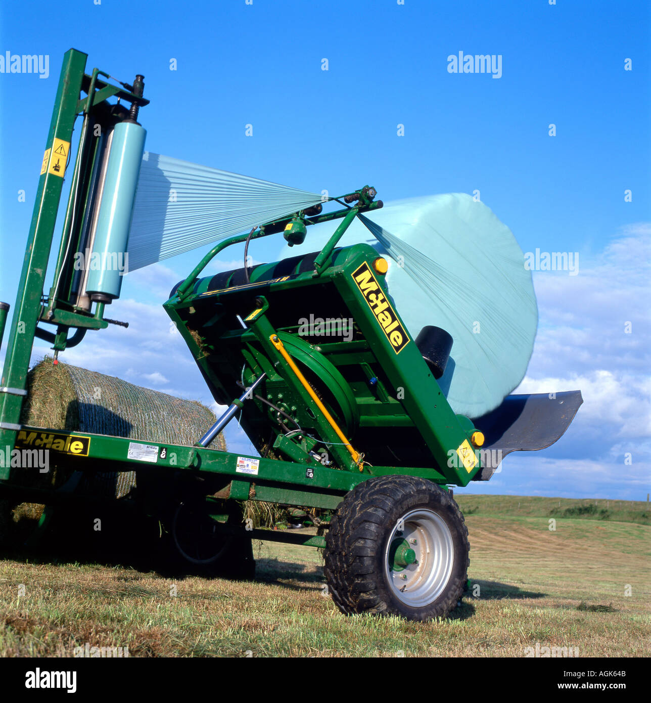 Round bales being wrapped using a tractor and silage equipment in ...