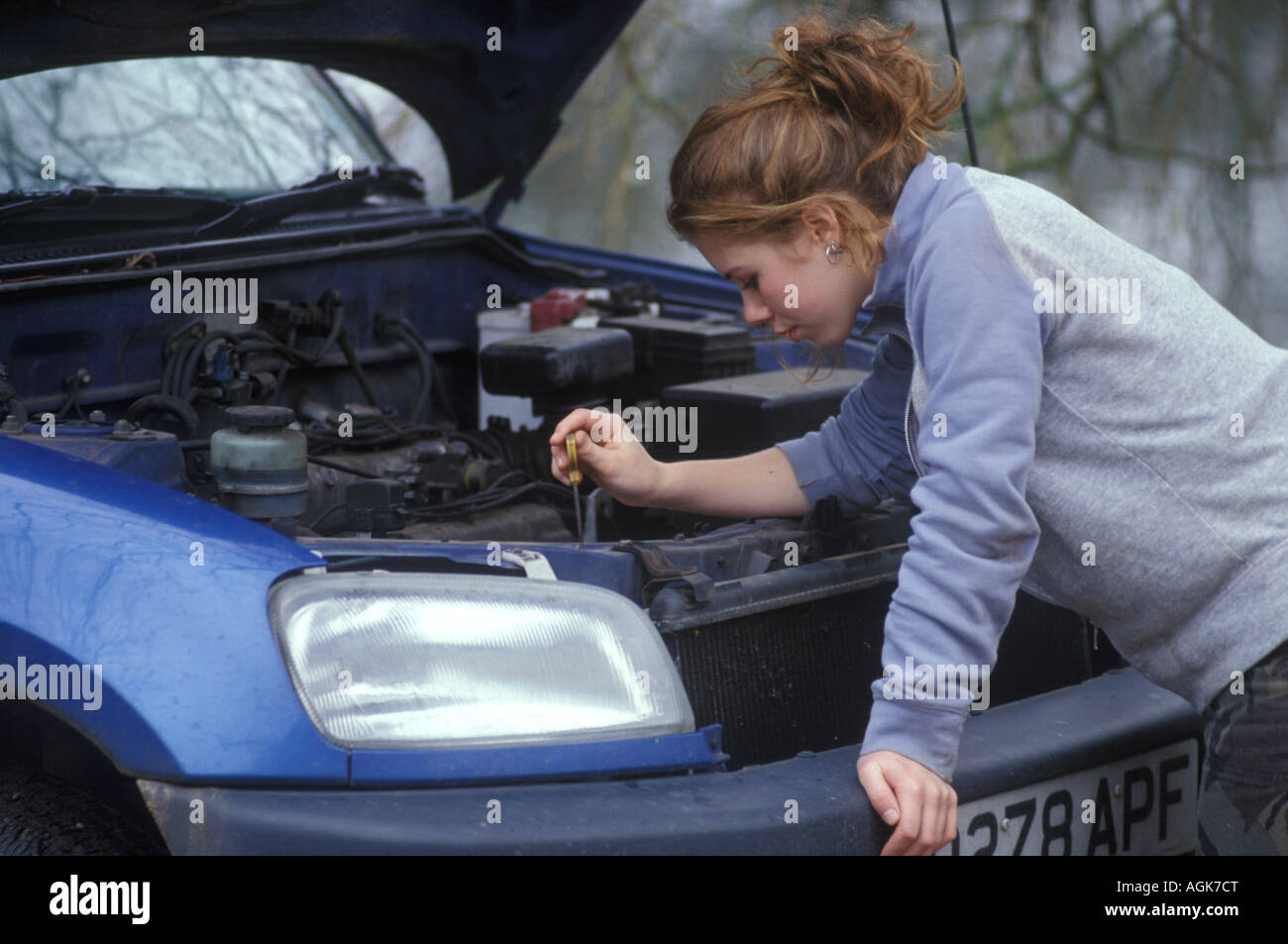 teenage girl doing maintenance work on a car Stock Photo - Alamy
