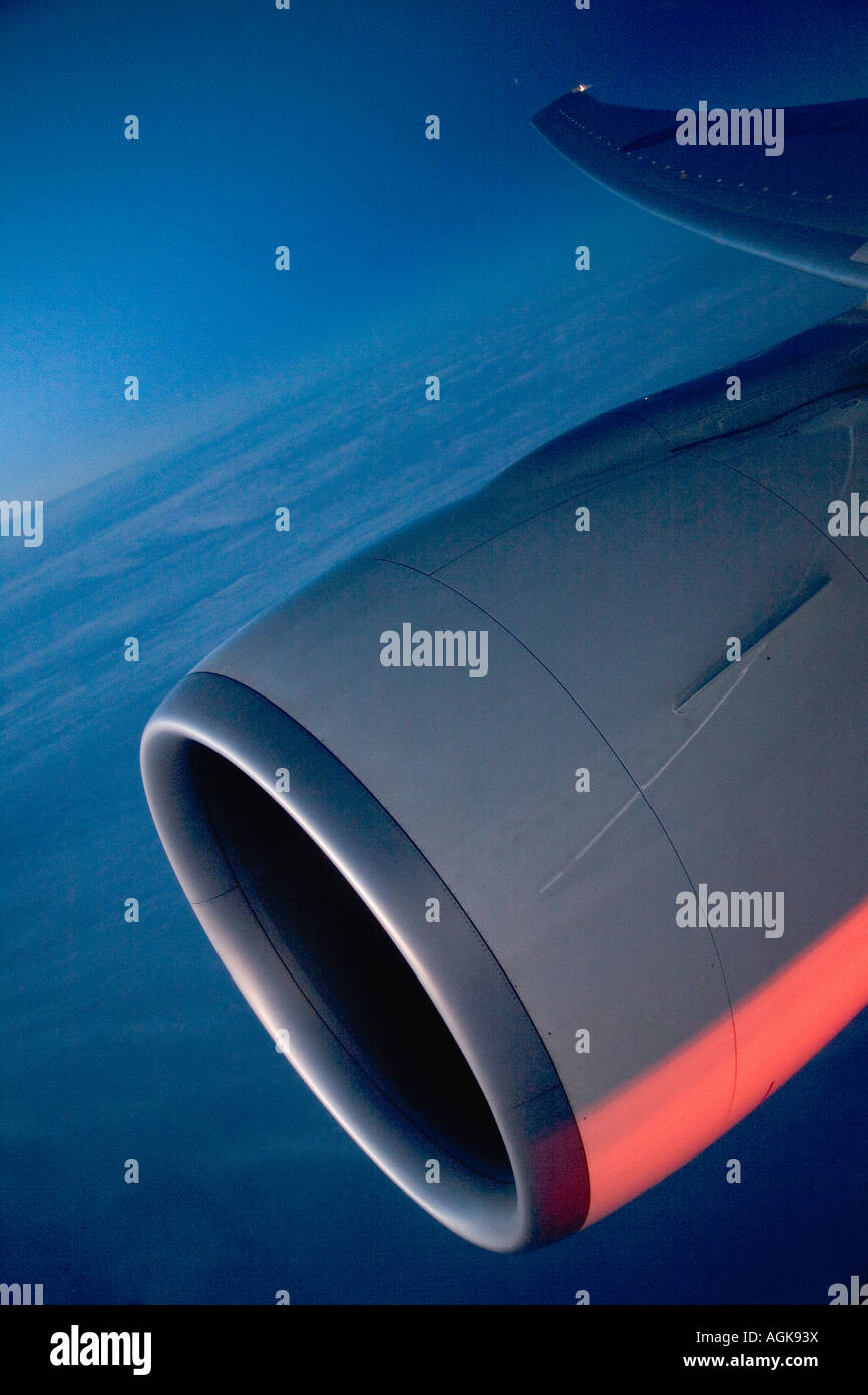 graphic shot of airplane wing and engine taken at sunrise showing pink ...