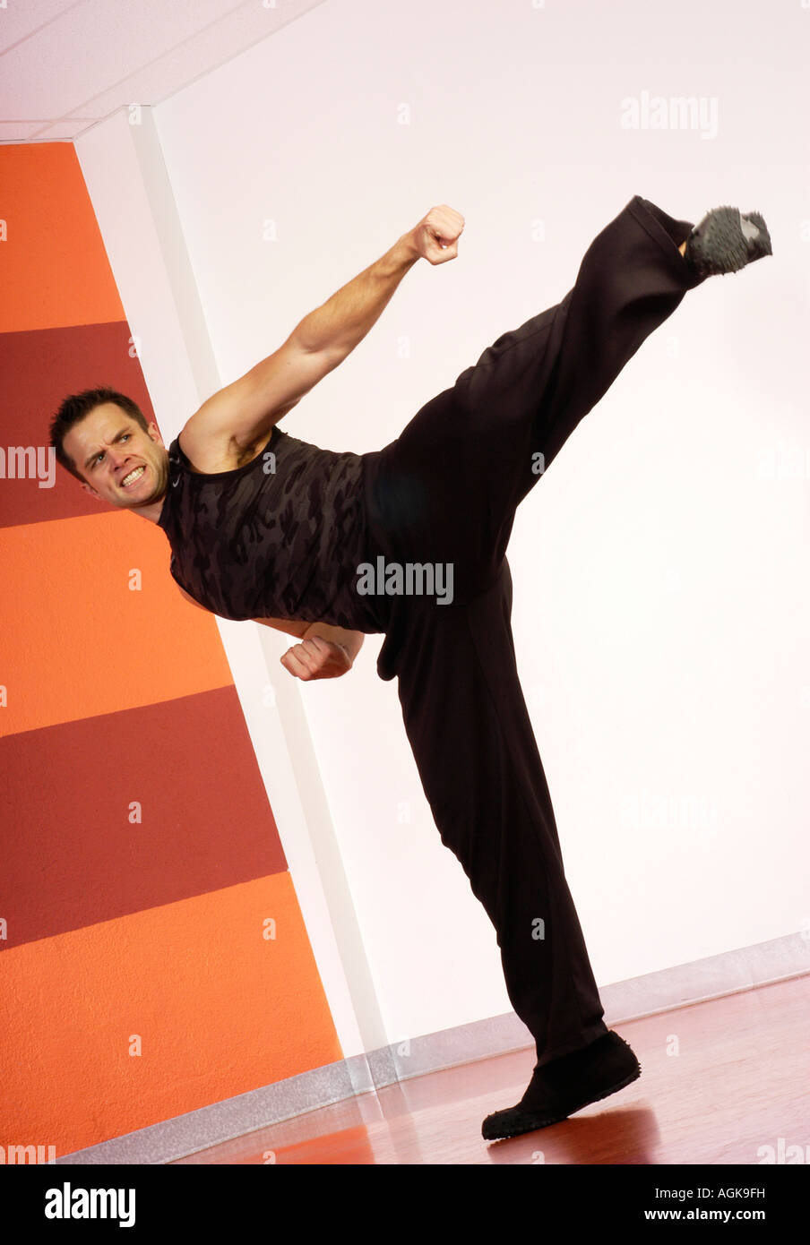 A young man does body attack kicks while teaching a body attack class ...