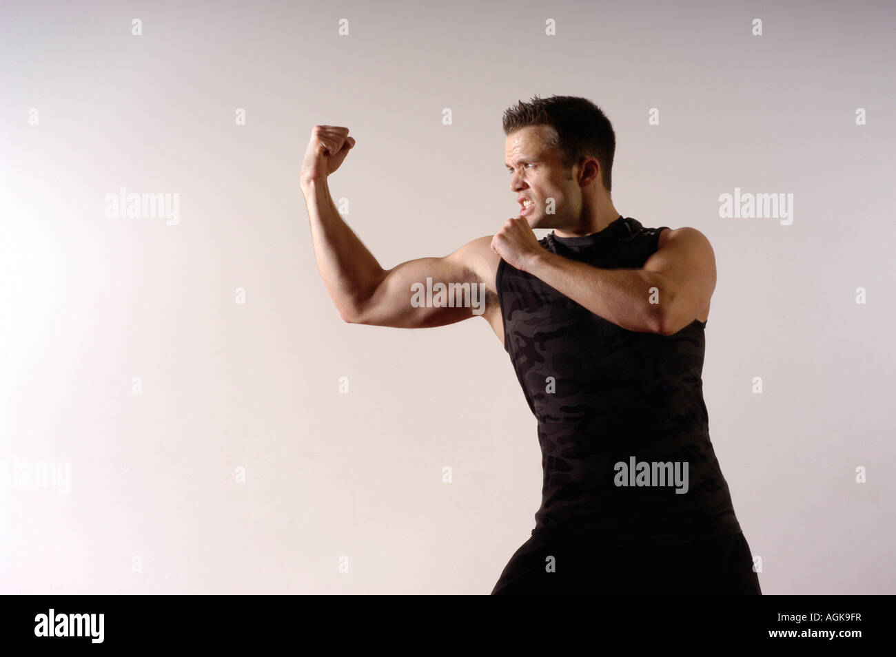 A young man does body attack move while teaching a body attack class ...